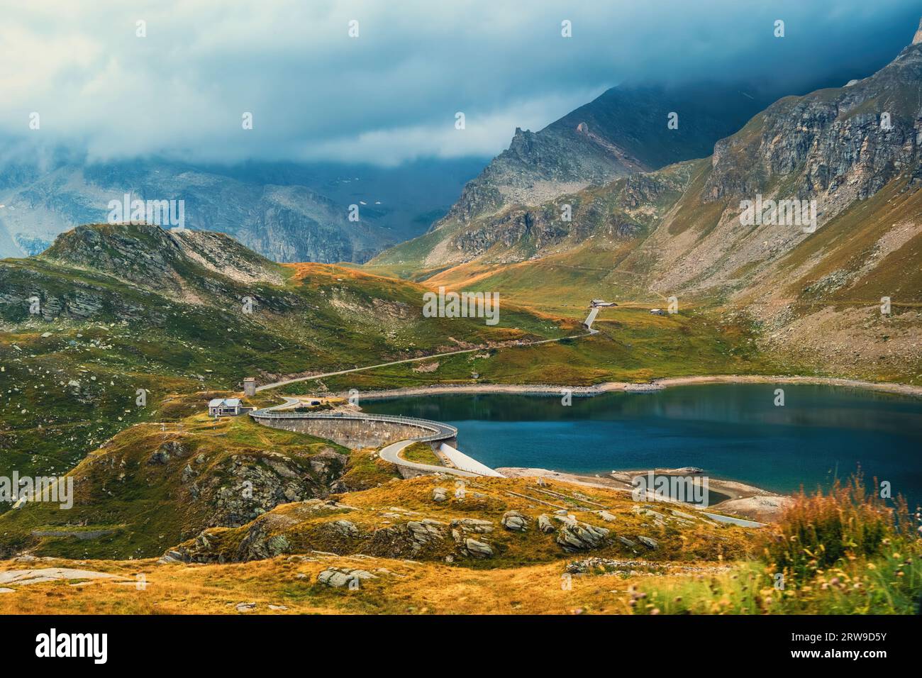 Small alpine lake Agnel among mountains under cloudy sky near Nivolet ...