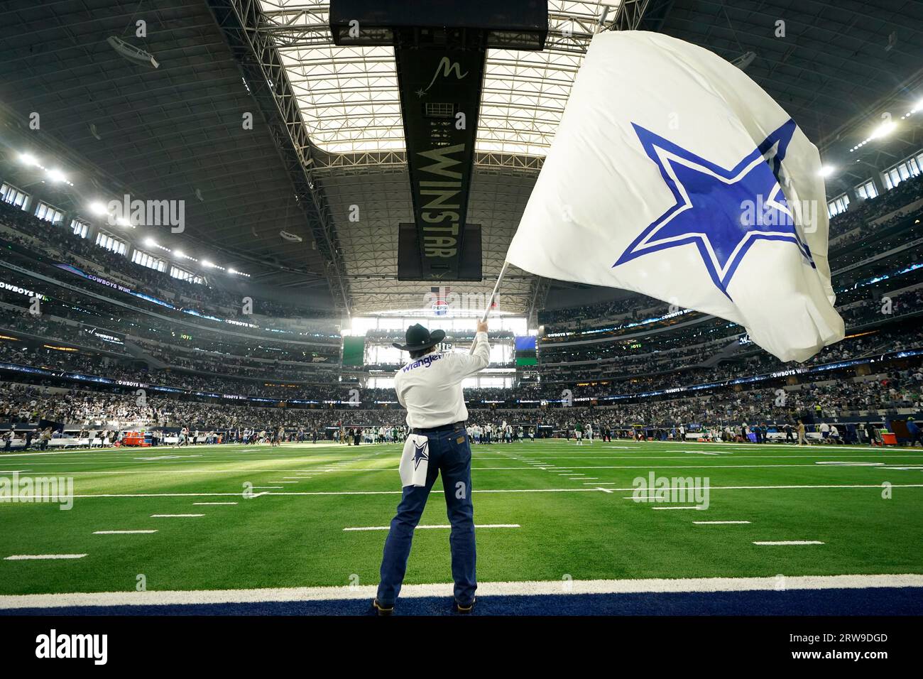 A member of the Dallas Cowboys spirit team waves a flag on the field ...