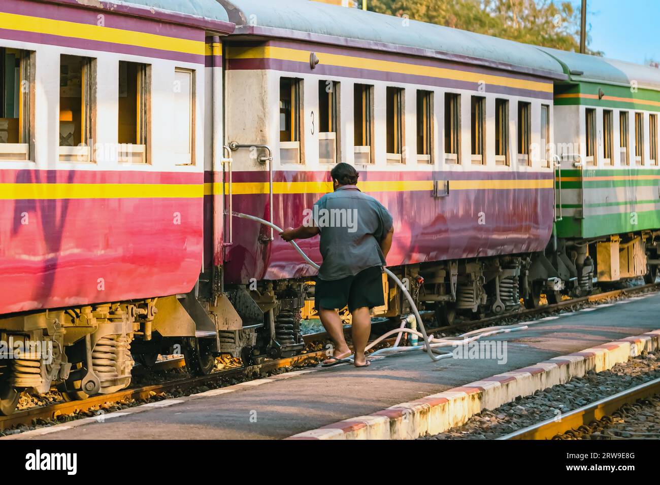 Male janitor clean and wash exterior of train. Worker cleaning the ...