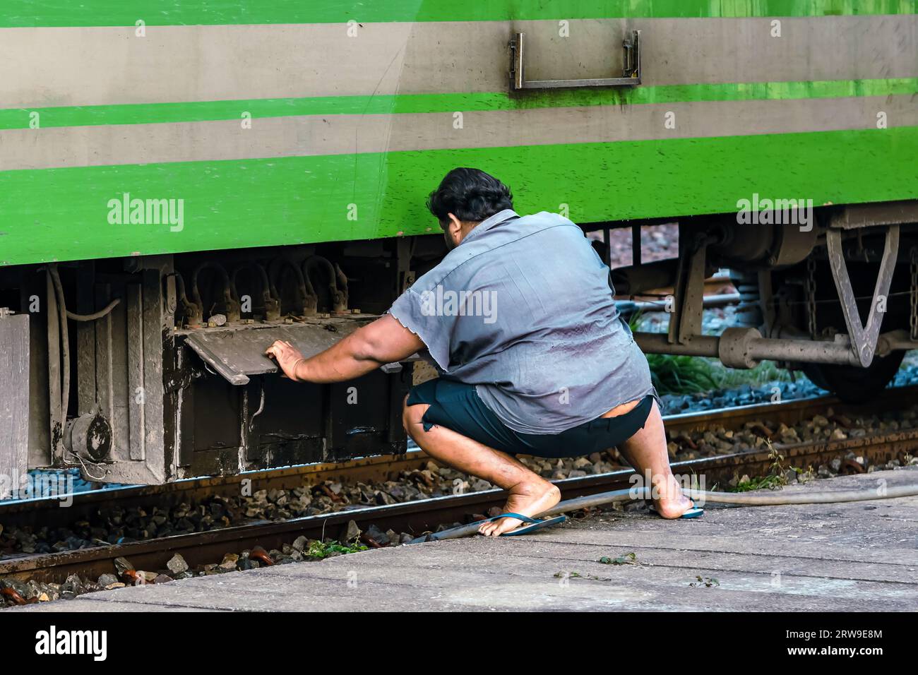 Male janitor clean and check exterior of train. Worker cleaning train ...