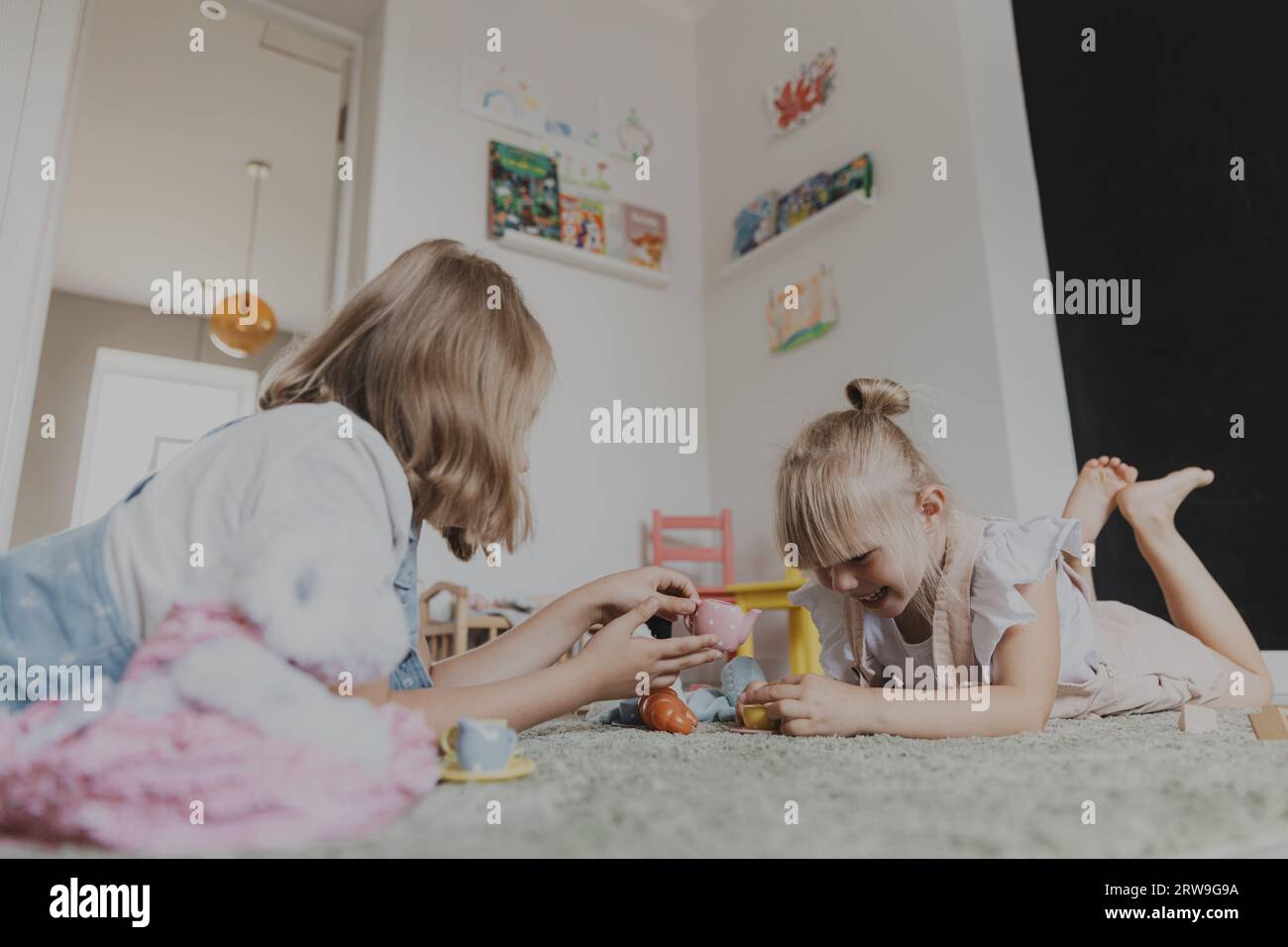 Children playing with colorful plastic toy play tea set. Kids lying on ...