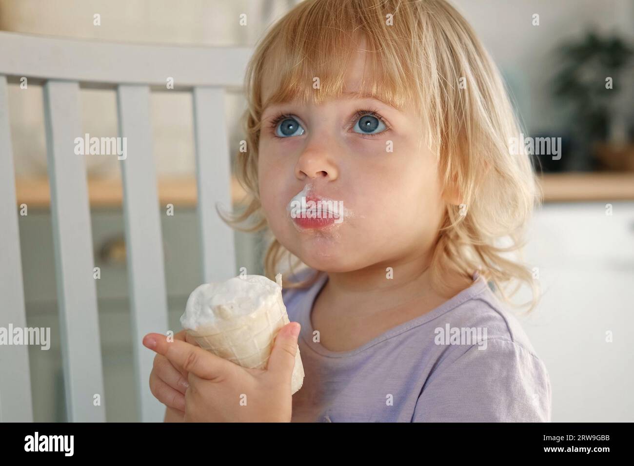 Baby girl enjoying ice cream. Pretty little toddler eating an ice-cream ...