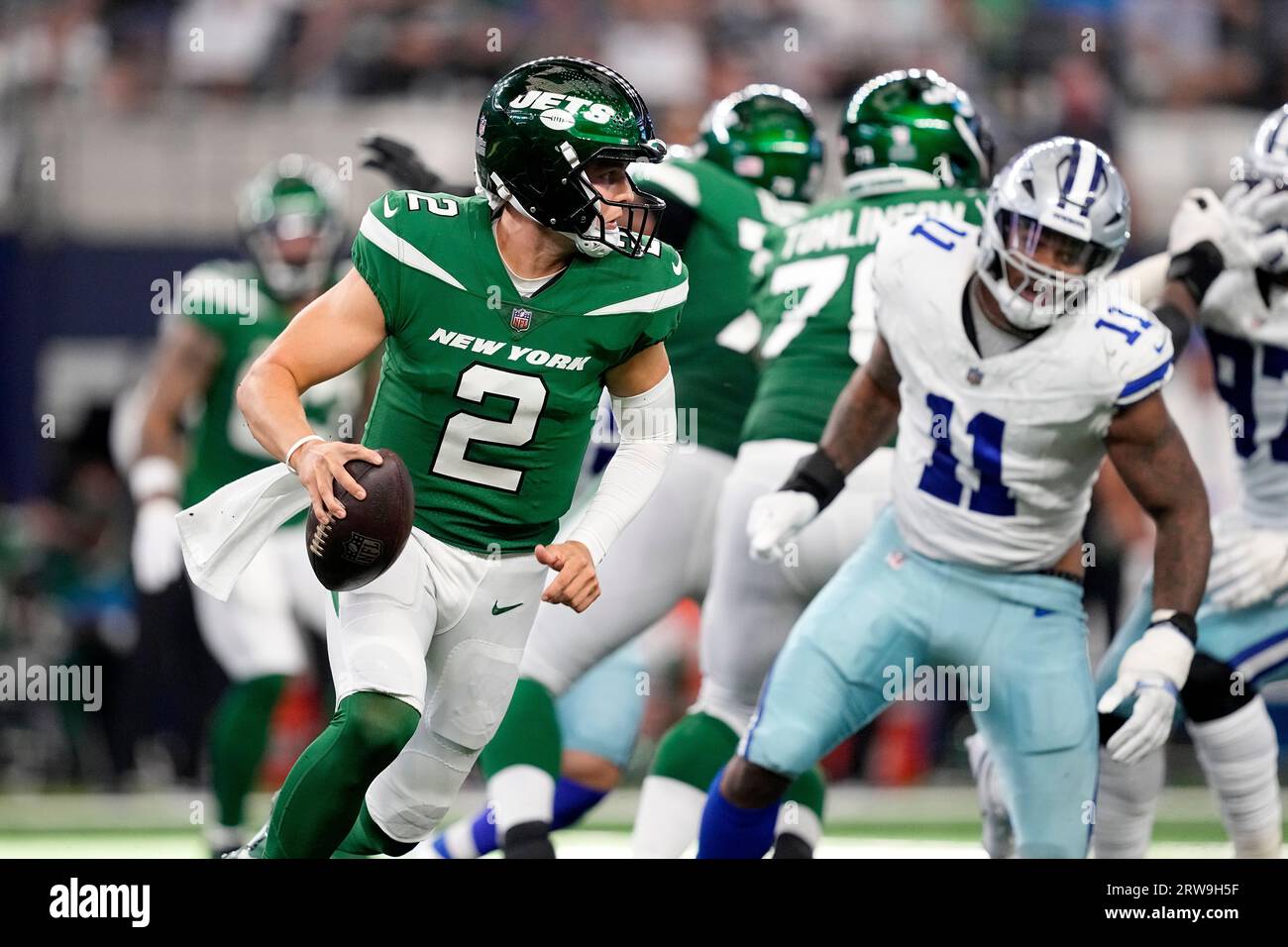 New York Jets quarterback Zach Wilson scrambles out of the pocket under ...