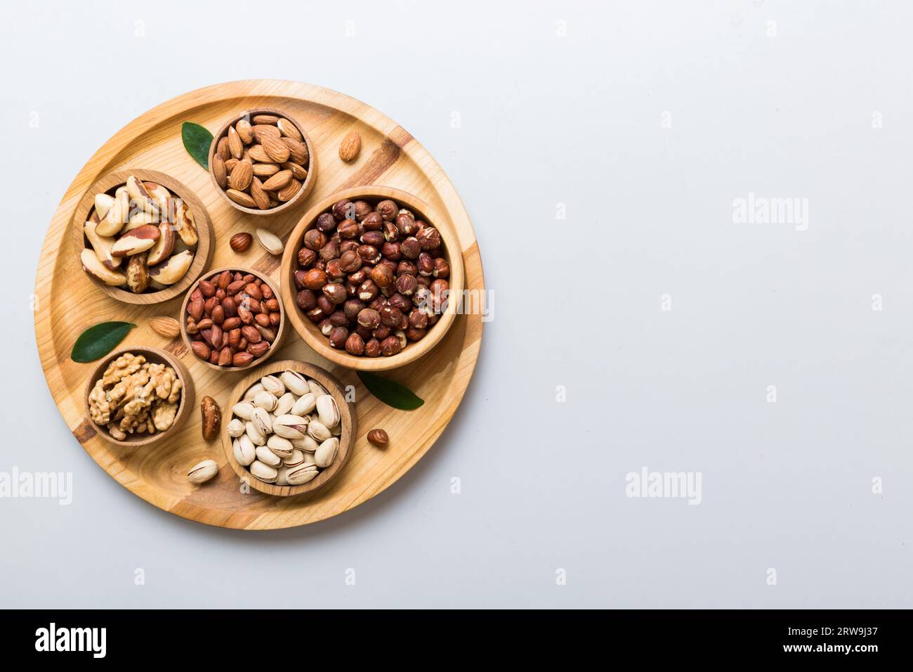 mixed nuts in wooden bowl. Mix of various nuts on colored background ...
