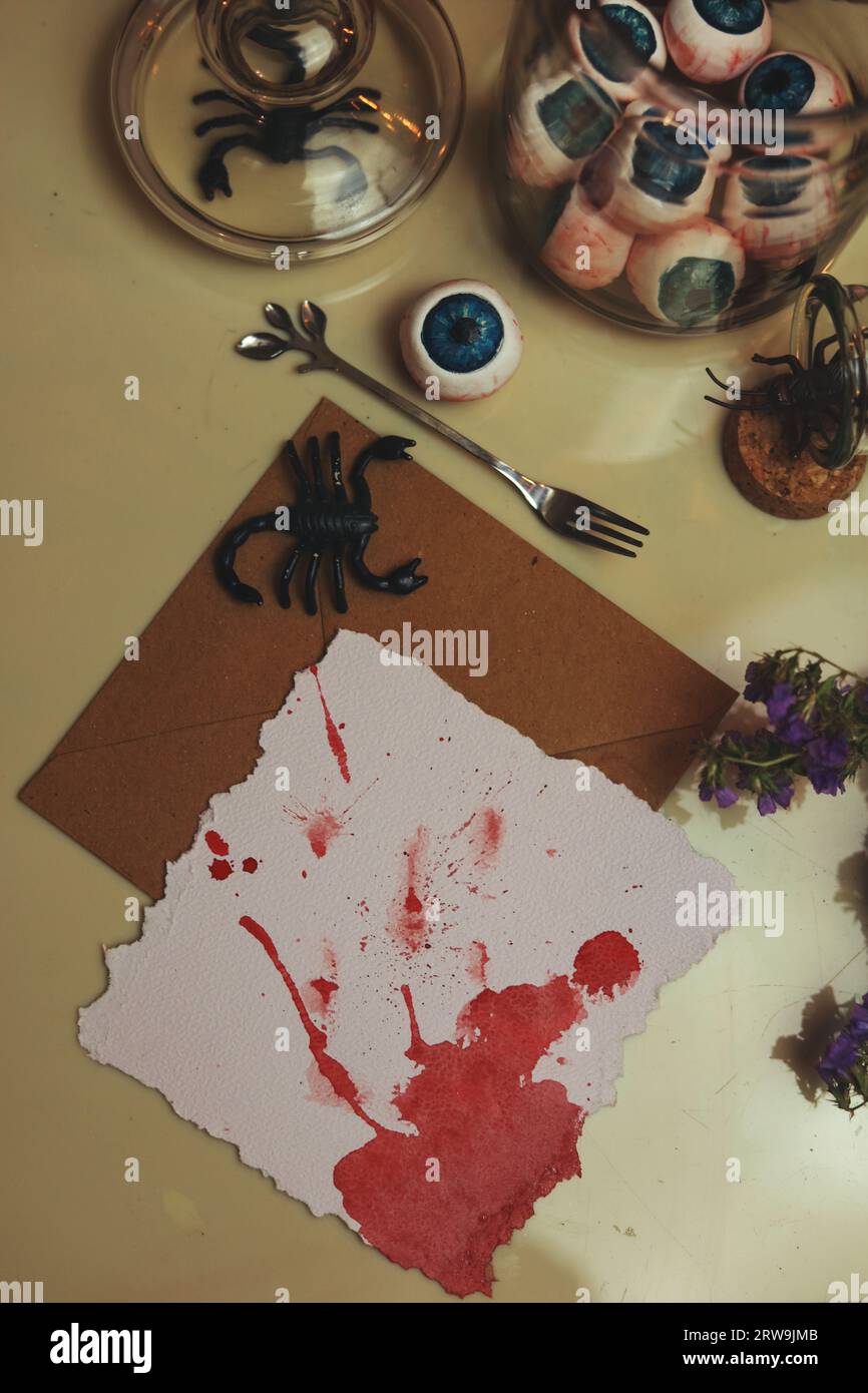 halloween still life with a blank bloody card, eyeballs, scorpions ...
