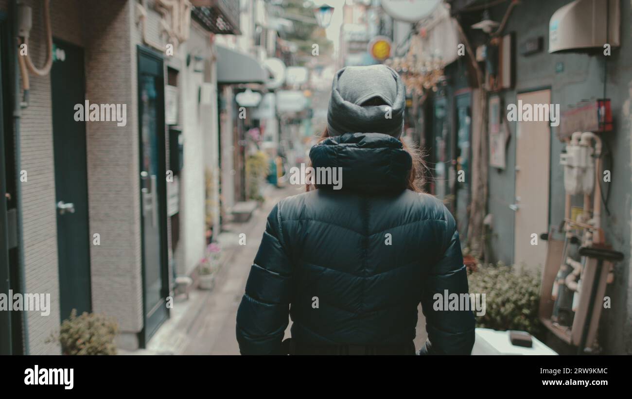 Woman tourist walking small city street in Tokyo. Caucasian girl enjoy ... Woman tourist walking small city street in Tokyo. Caucasian girl enjoy ...