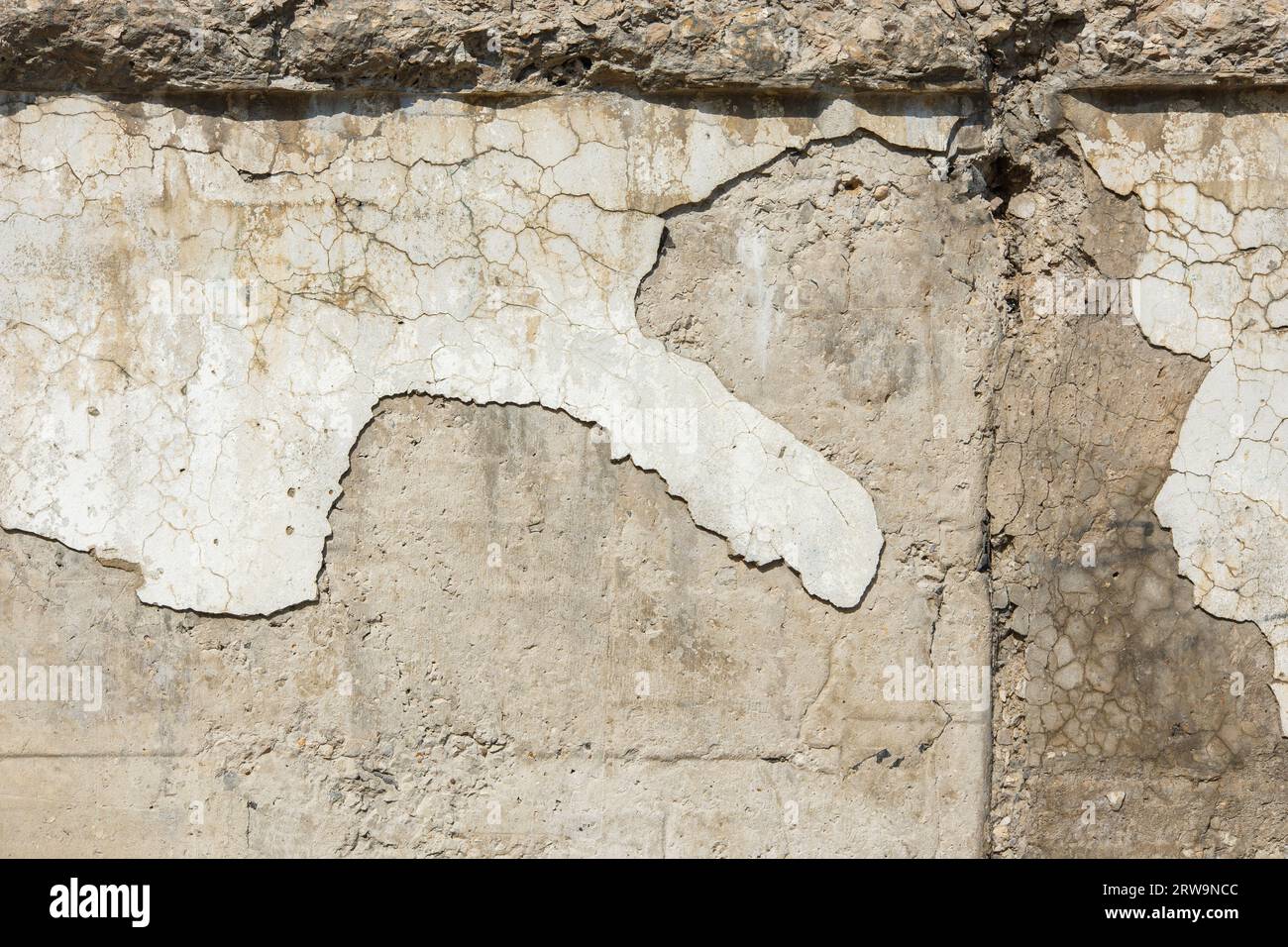 peeled off plaster on distressed concrete wall under direct sun light ...