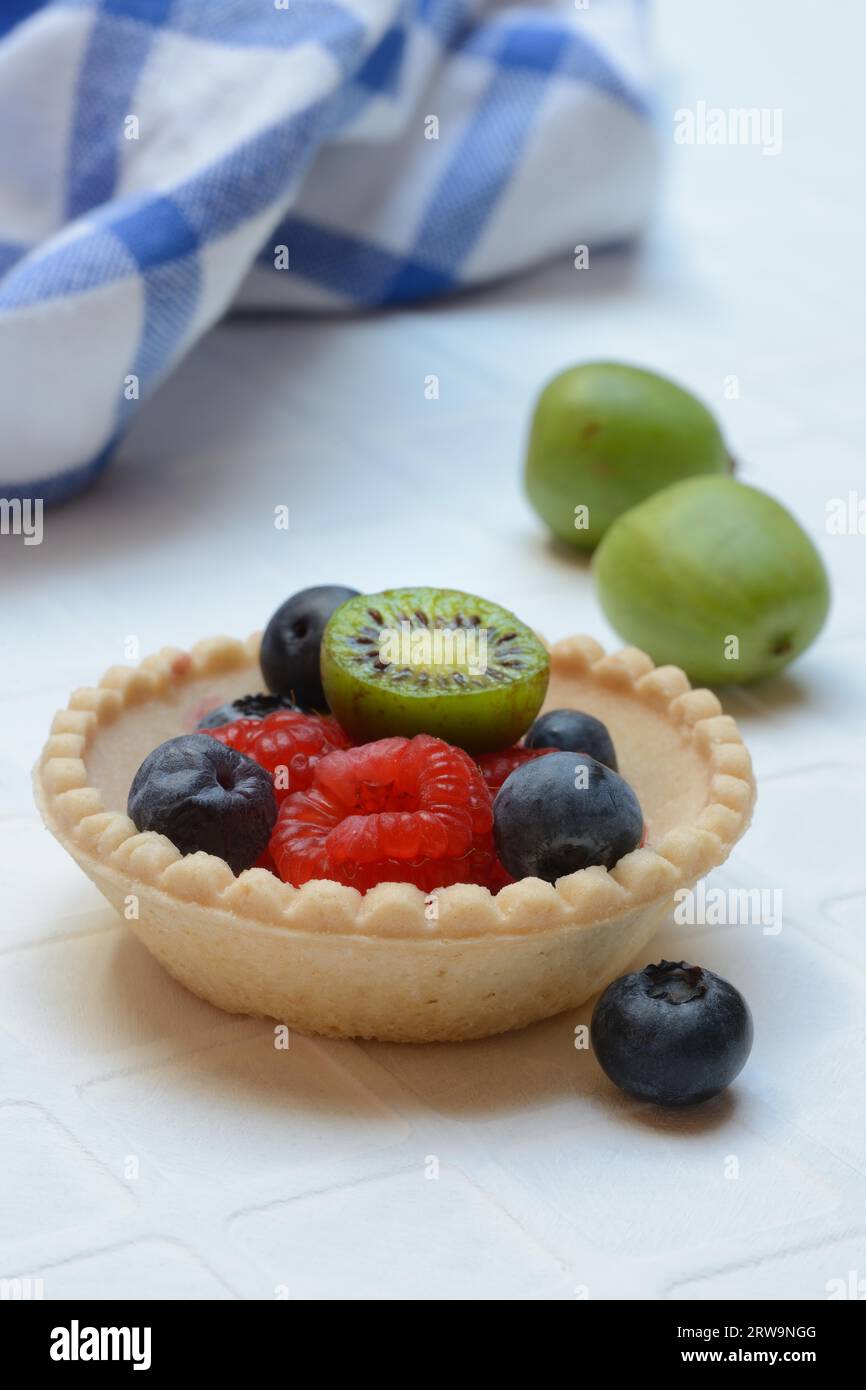 Fruit in tartlet base, raspberry, blueberry, mini kiwi Stock Photo - Alamy
