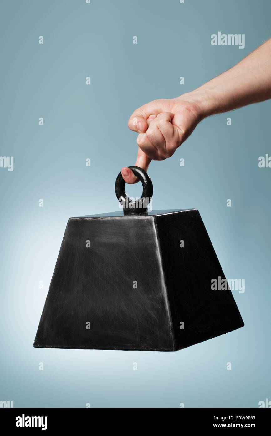 Man holding a seemingly heavy weight that is a fake prop Stock Photo ...