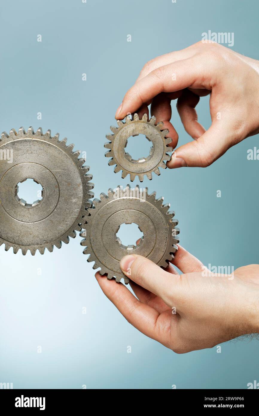 Man designing a mechanical system using old cog gear wheels Stock Photo ...