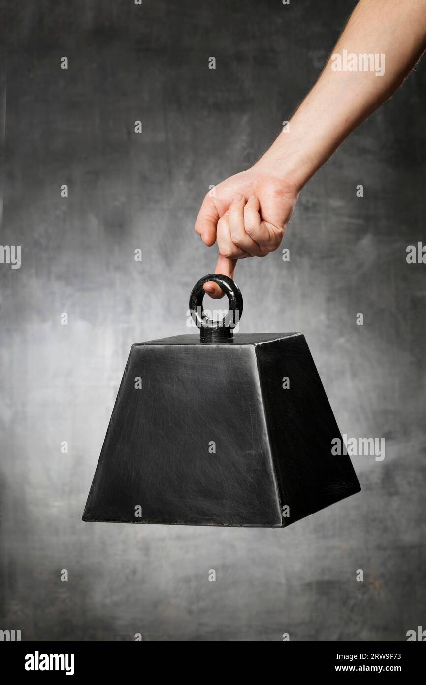 Man hanging a fake prop weight from his finger Stock Photo - Alamy