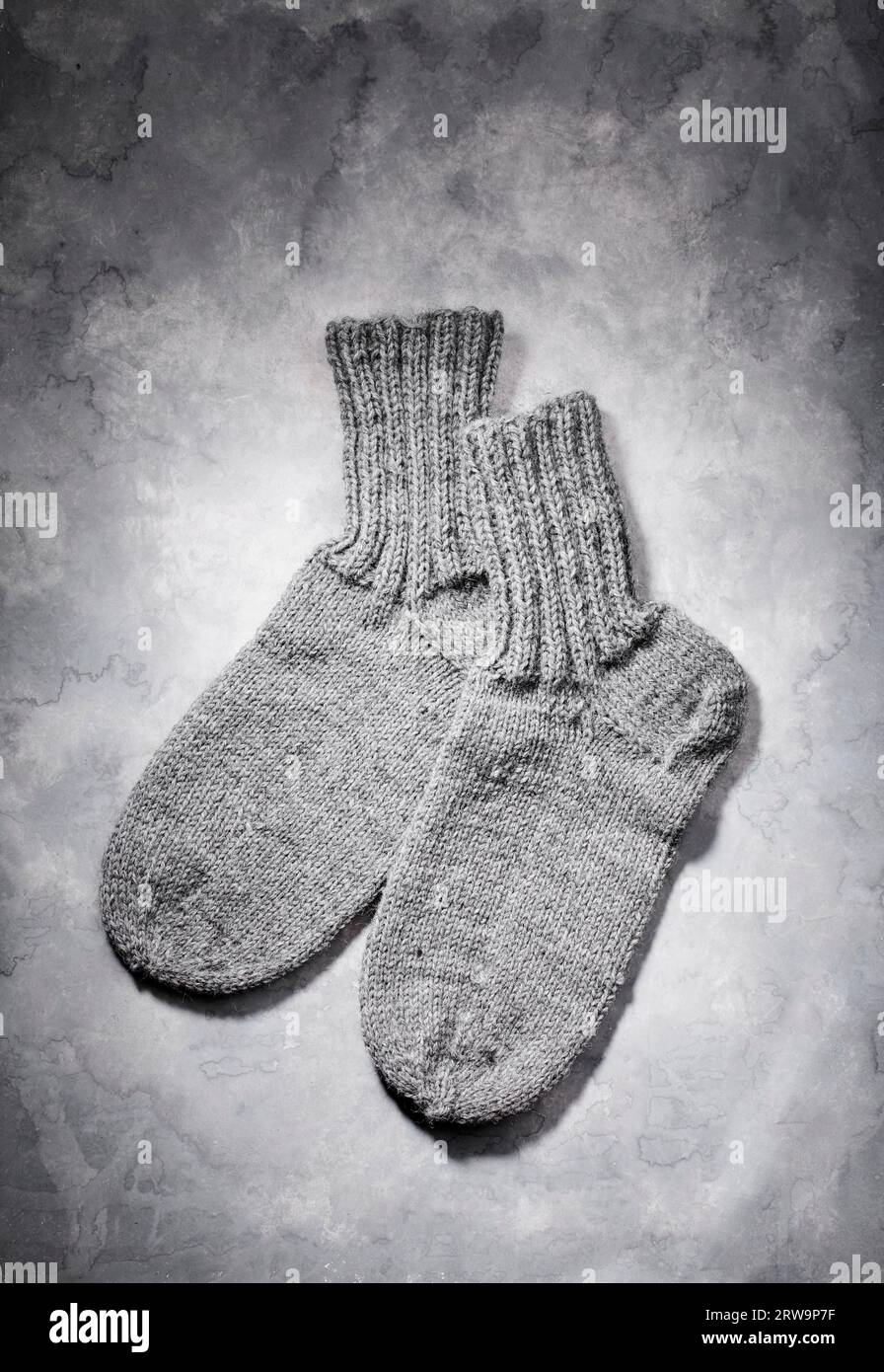 Hand-knitted grey wool socks on grey background Stock Photo - Alamy