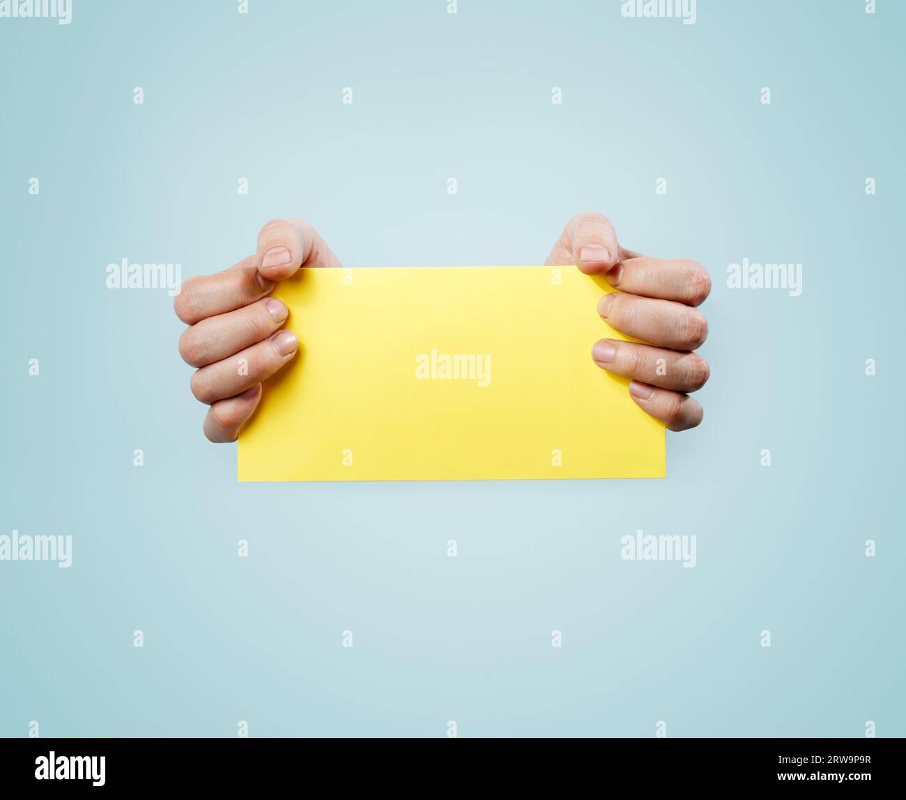 Hands holding a yellow card Stock Photo - Alamy