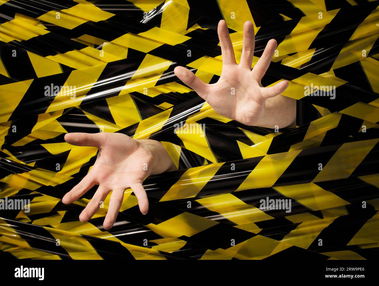 A Man trapped behind yellow and black barrier tape Stock Photo - Alamy