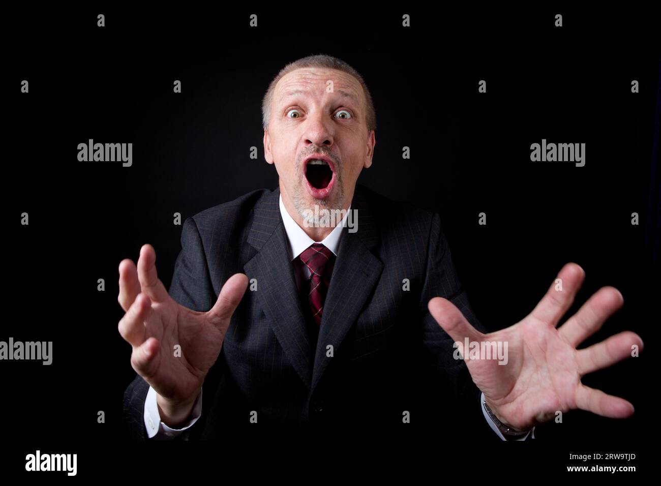 Mature businessman stretching arms and shouting at camera. Black ...