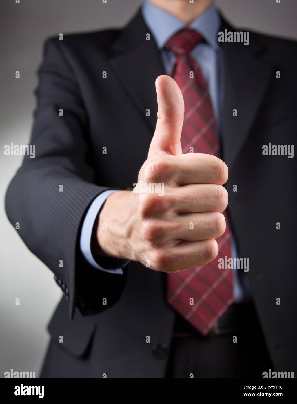 Businessman showing thumbs up sign. Neutral background Stock Photo - Alamy