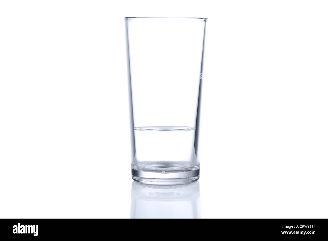 Glass with small amount of water on white background Stock Photo - Alamy