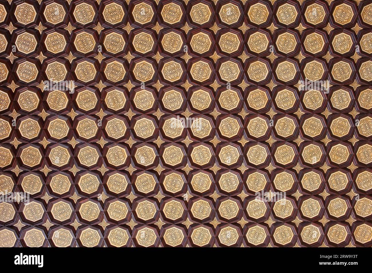 Old, traditional golden painted design within wooden octagon shape ...