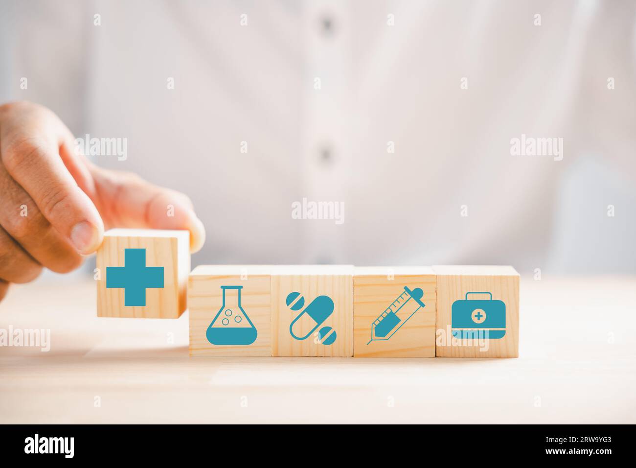 Hand hold wooden block with icon healthcare medical Stock Photo - Alamy