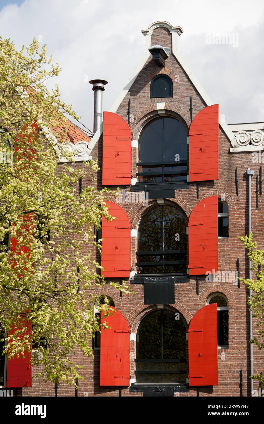 Historic house with red window shutters and triangular gable, converted ...