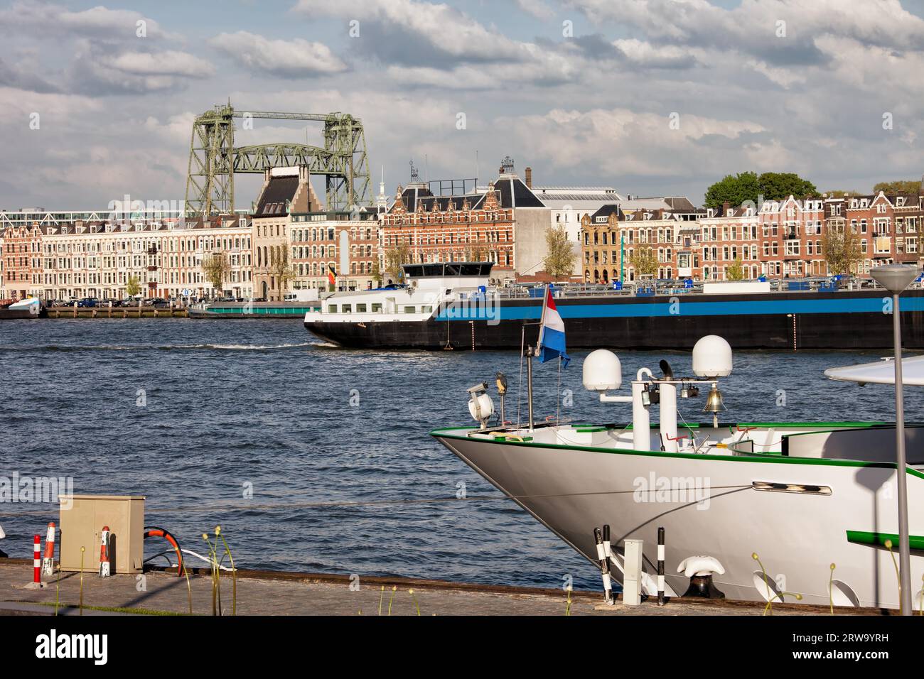 City of Rotterdam urban scenery, riverside housing, barges and ships on ...