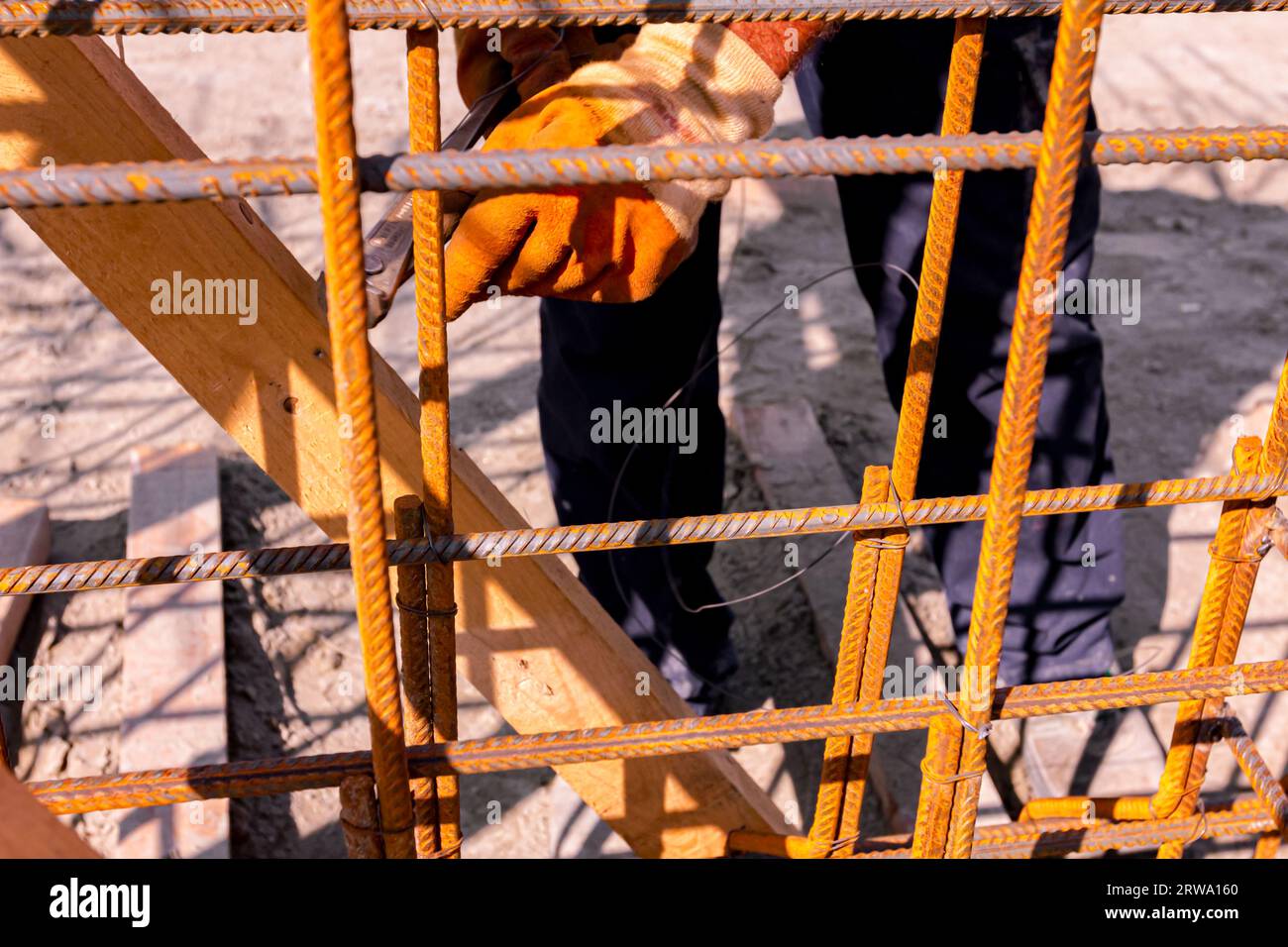 Worker is tying rebar with wire using pliers, to make a reinforcing ...