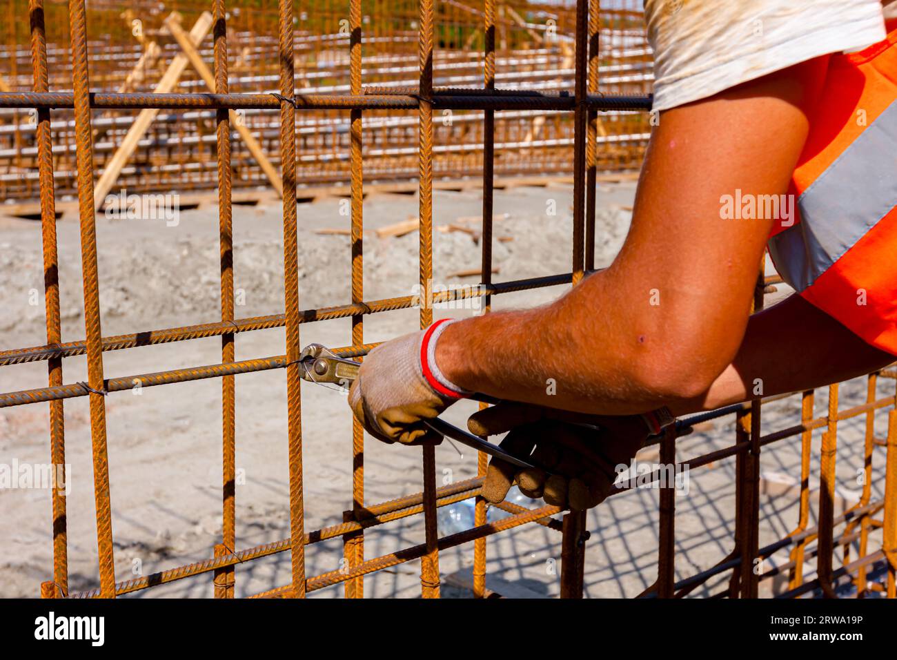 Worker is tying rebar with wire using pliers, to make a reinforcing ...
