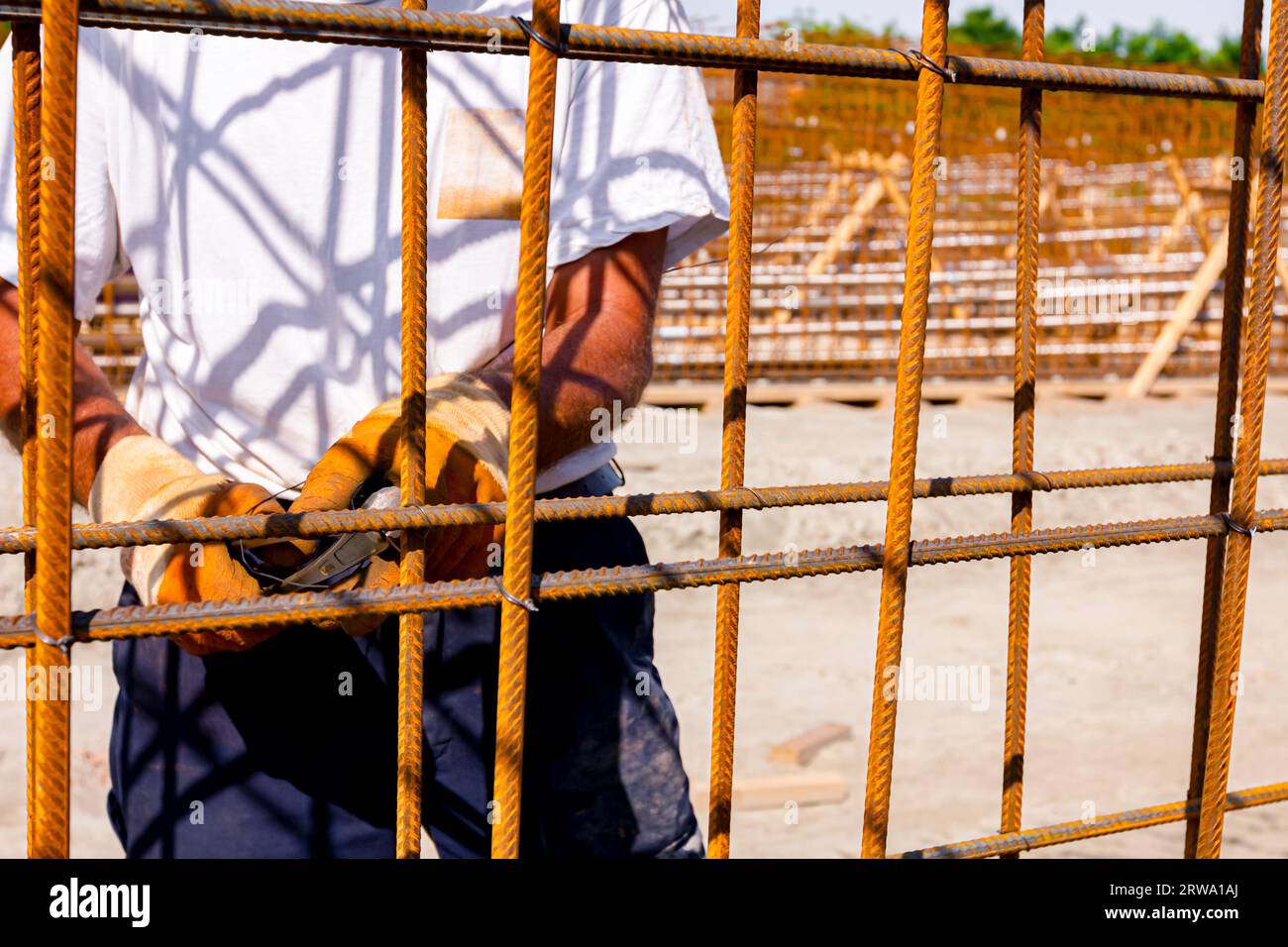 Worker is tying rebar with wire using pliers, to make a reinforcing ...