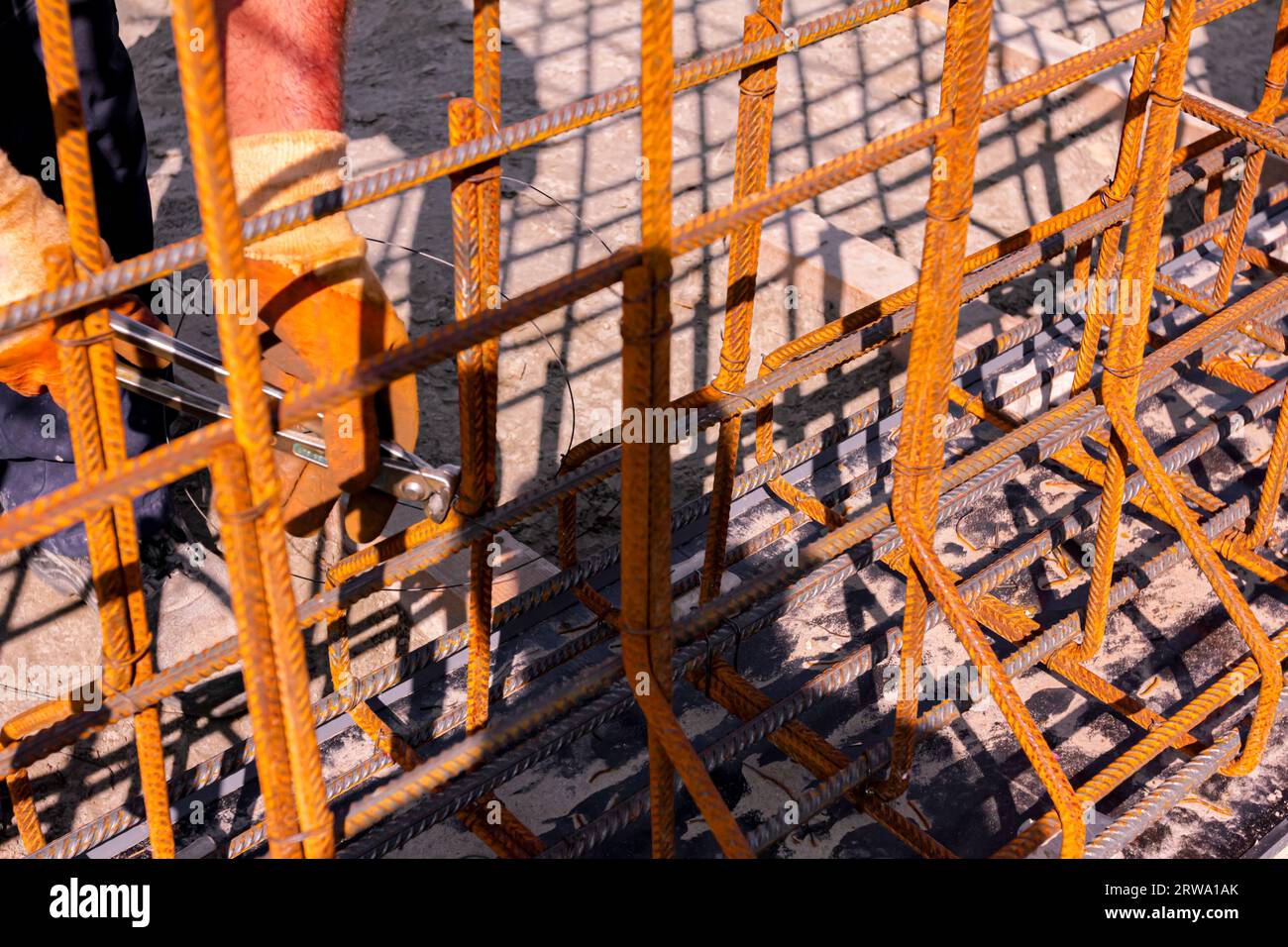 Worker is tying rebar with wire using pliers, to make a reinforcing ...