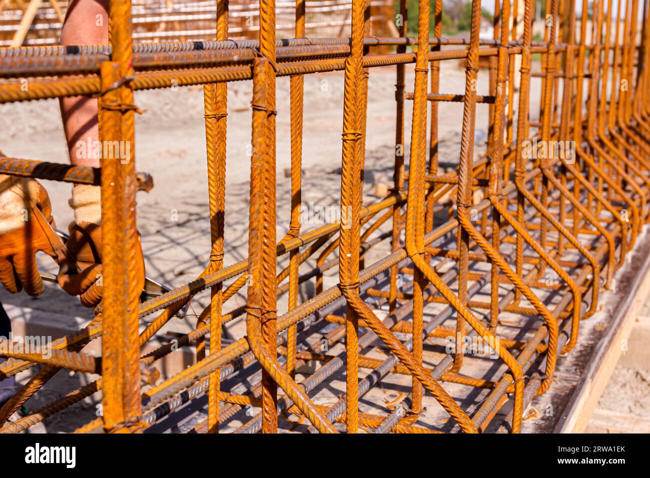 Worker is tying rebar with wire using pliers, to make a reinforcing ...