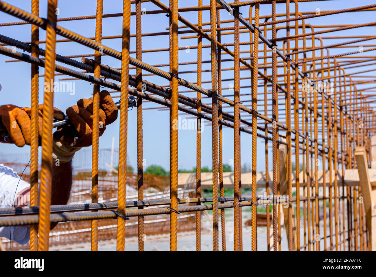 Worker is tying rebar with wire using pliers, to make a reinforcing ...