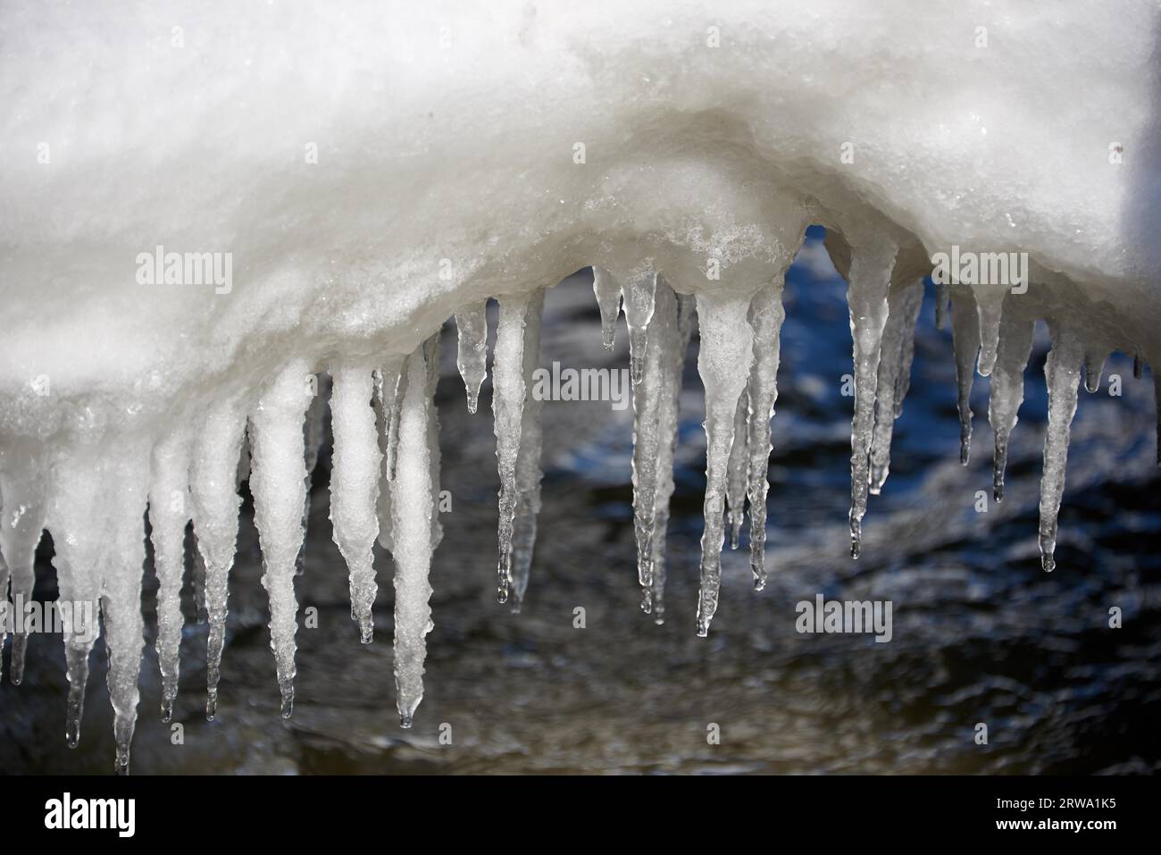 Icicle hanging down from snowy pier Stock Photo - Alamy
