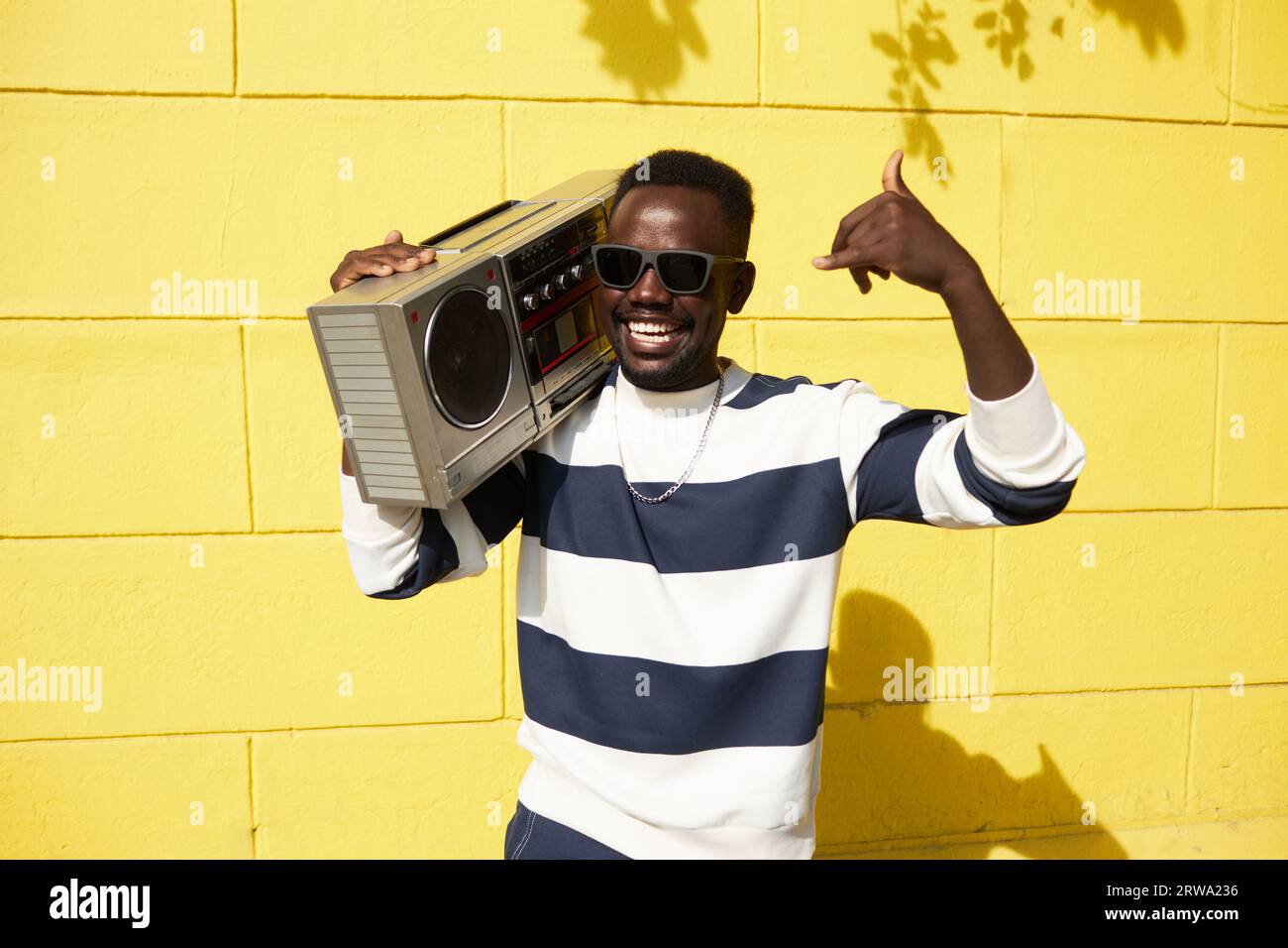 Vibrant waist up portrait of funky Black man holding boombox outdoors ...