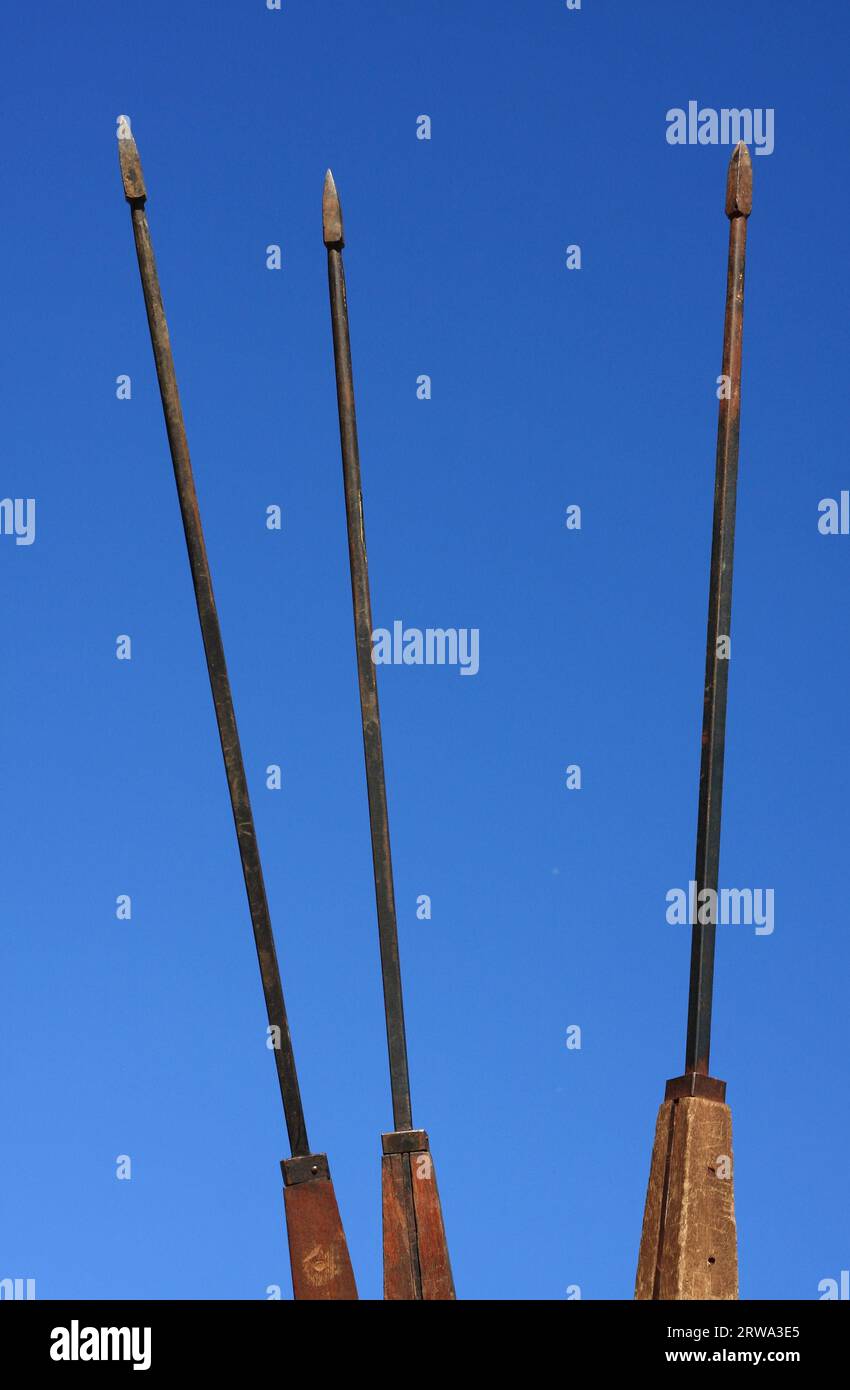 Three Roman spears against a blue sky, photographed in portrait format ...