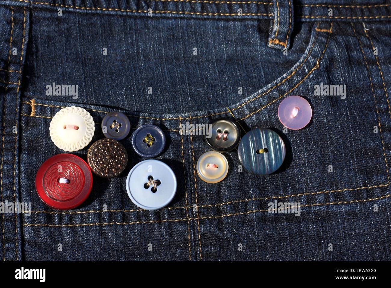Buttons in different colours and different sizes, sewn on the pocket of ...
