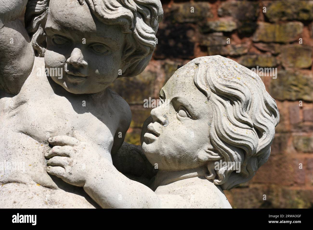 Two putti with tender gestures, sunlit, background wall Stock Photo - Alamy