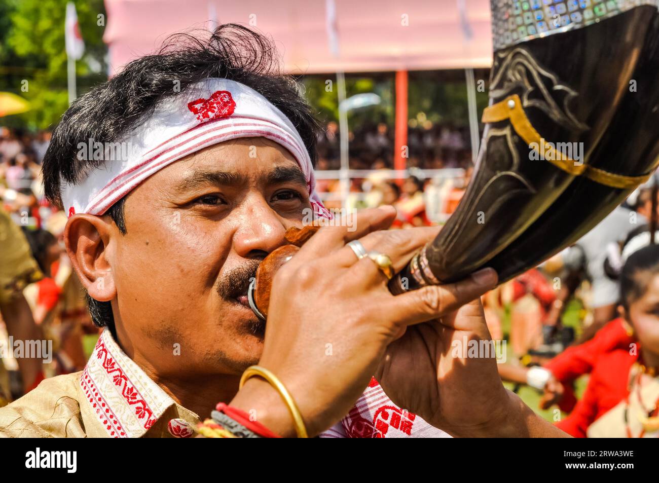 Guwahati, Assam, circa April 2012: Native man blows horn during performance at traditional Bihu ...