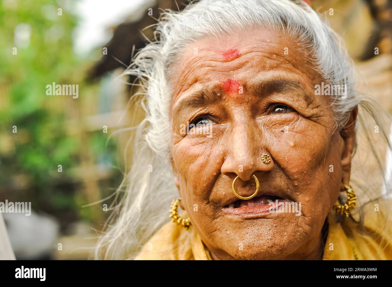 Damak, Nepal, circa May 2012: Old woman with red dots on her forehead ...