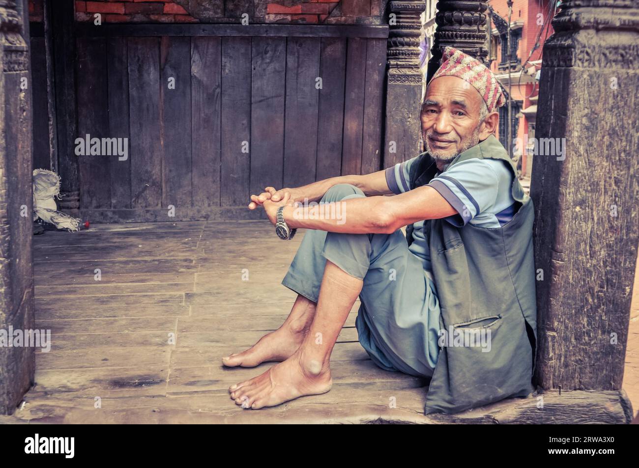 Bhaktapur, Nepal, circa June 2012: Native man in blue clothes and cap ...