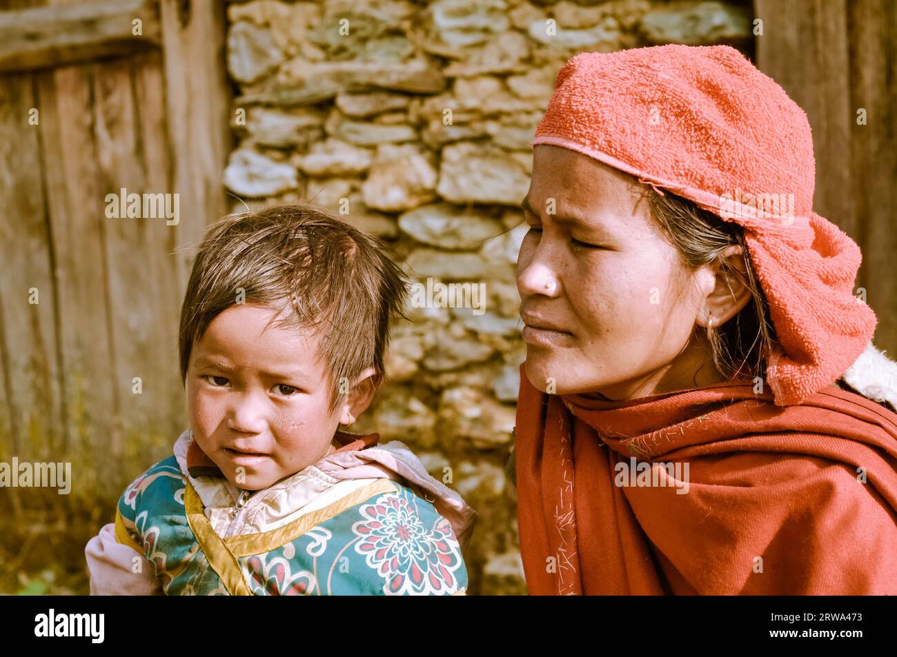 Beni, Nepal, circa May 2012: Photo of mother in red scarf and headcloth ...