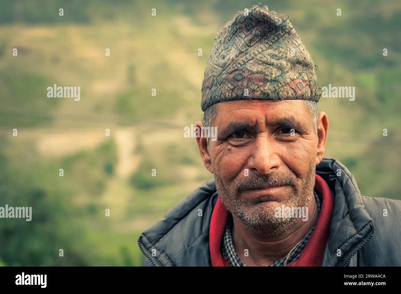 Dolpo, Nepal, circa June 2012: Brown-eyed man with cap dressed in red ...