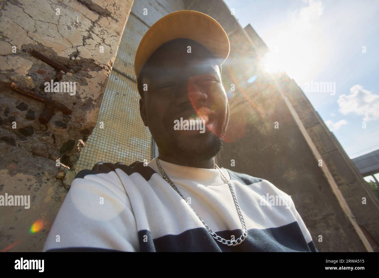 Low angle candid shot of smiling black man in urban setting with lens ...