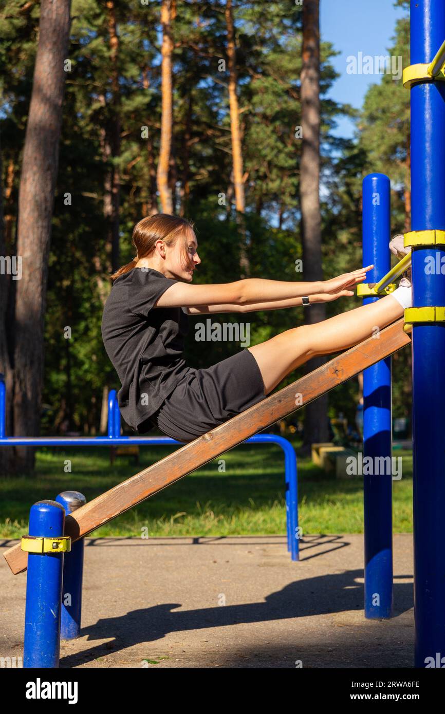 A teenage girl doing abdominal crunches. A girl performs exercises for ...