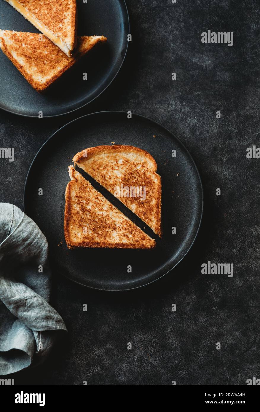 Top view of grilled cheese sandwiches on black plates and background ...
