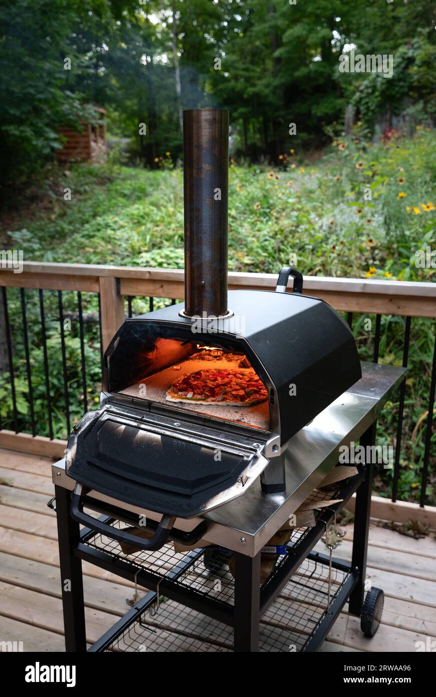 Portable pizza oven cooking a homemade pizza on a deck Stock Photo - Alamy