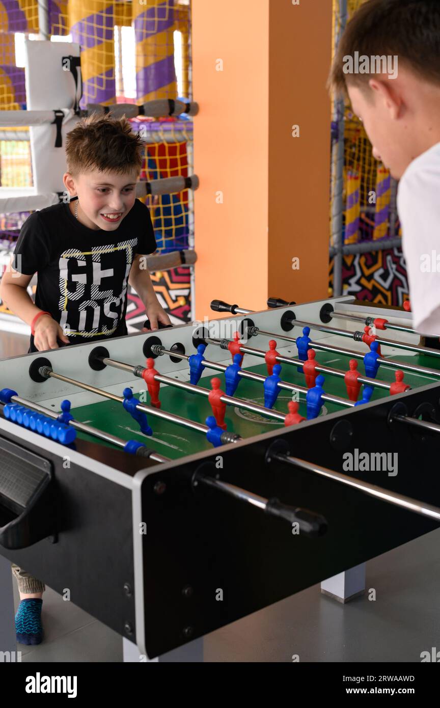Two boys in the game room playing table football, mental and active ...