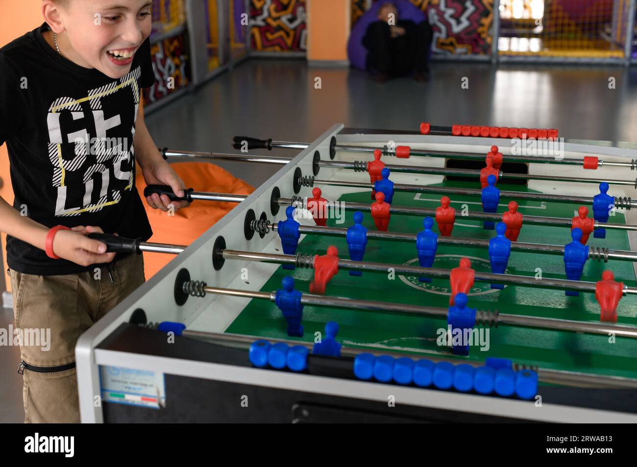 Active recreation in the game room, children play table football ...