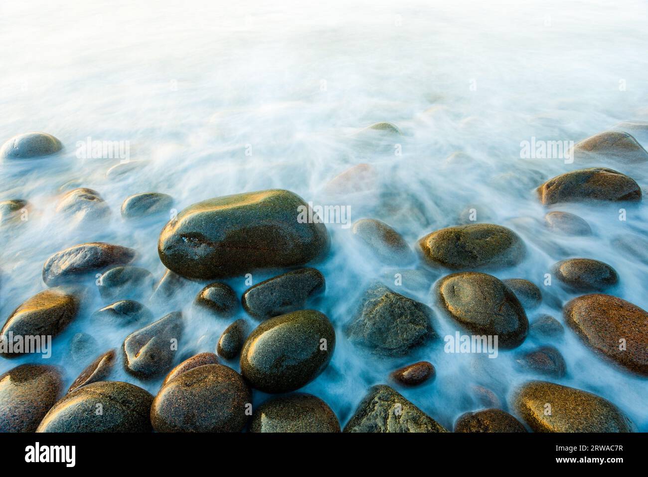 Incoming Tide on Pebble Beach Stock Photo - Alamy