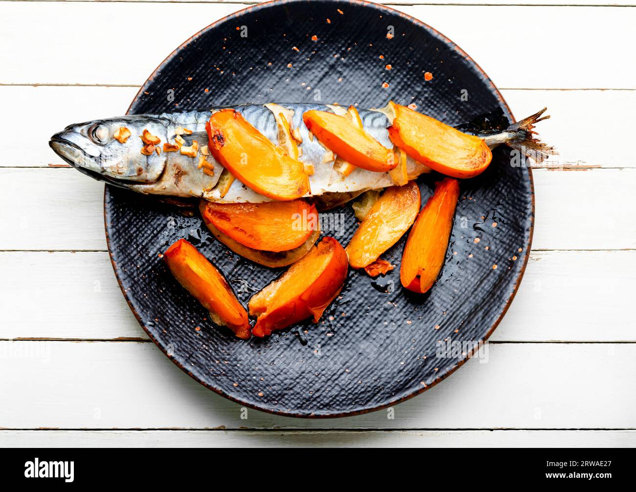 Fish cooked in persimmon fruit marinade. Whole baked fish, mackerel ...