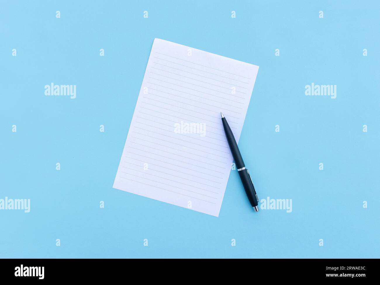 Blank white paper and pen isolated on blue background. After some edits ...